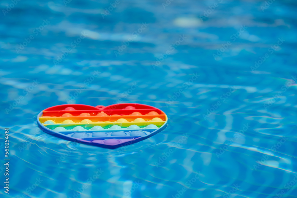Popular anti stress bubble fidget toy floating over swimming pool water ...