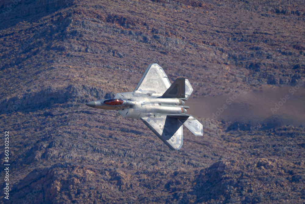 F-22 Raptor in a tight turn against the Nevada hills, with afterburners ...