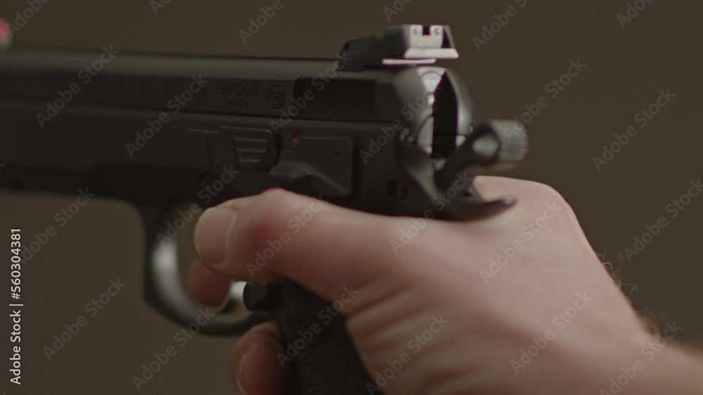 Thumb flipping down safety catch of 9mm pistol and dry firing - close ...