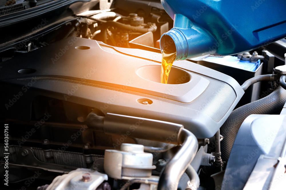 Refueling and pouring oil quality into the engine motor car ...