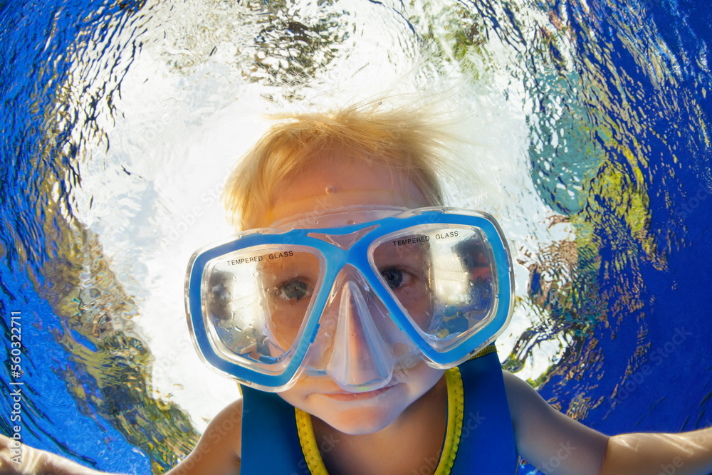 Happy little kid in snorkeling mask jump and dive underwater in coral ...