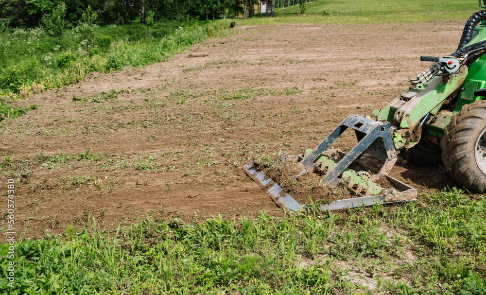 Land work by the territory improvement. Small tractor with a ground ...