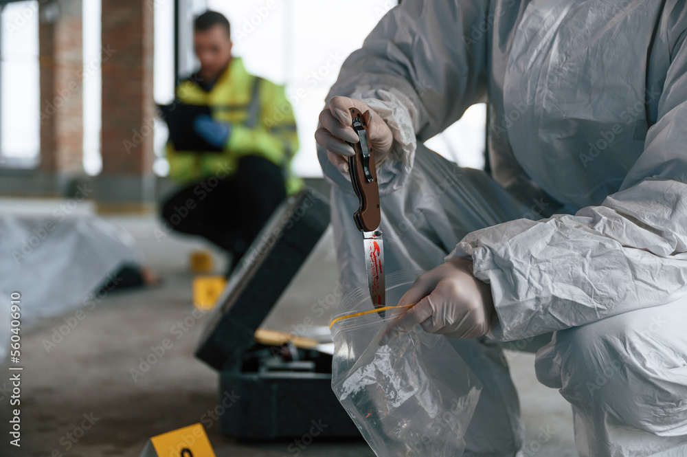 Putting the knife into bag. Detectives are collecting evidence in a ...