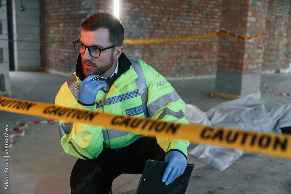 Sitting near caution police tape. Detectives are collecting evidence in ...