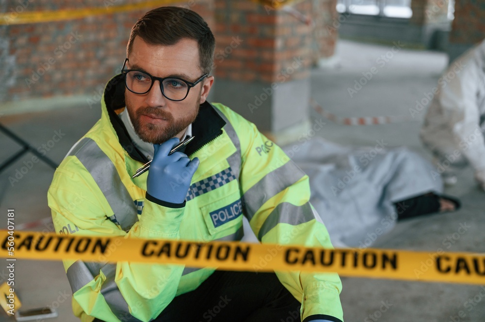 Sitting near caution police tape. Detectives are collecting evidence in ...