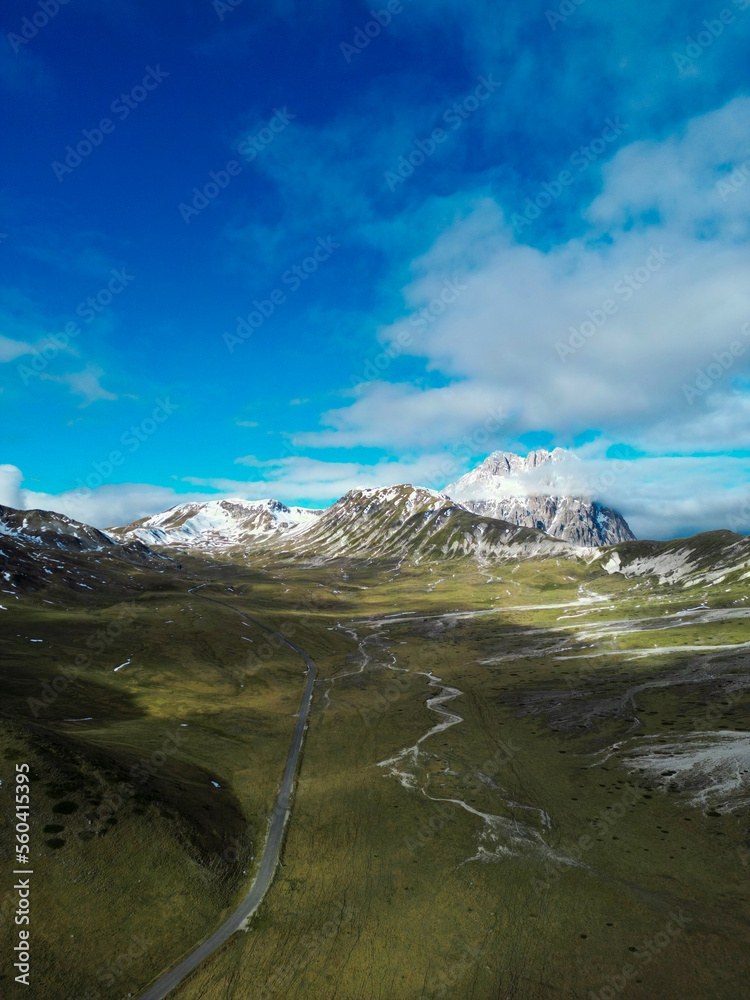 Stunning vertical mountain landscape framed by a blue sky with clouds ...
