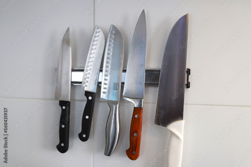 Chef's knives hanging on the wall. Knives on magnetic band. Kitchen ...