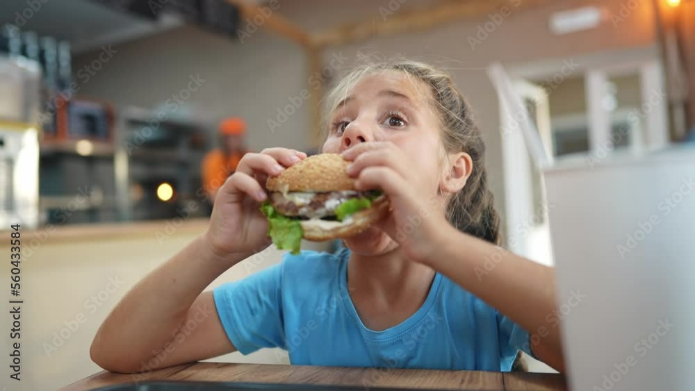child kid eating a burger in a cafe. fast food nutrition health concept ...