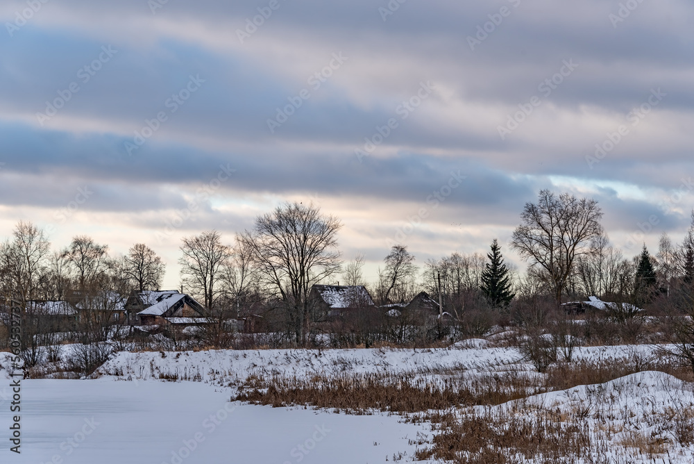 Rural landscape with village huts covered with white snow in winter ...