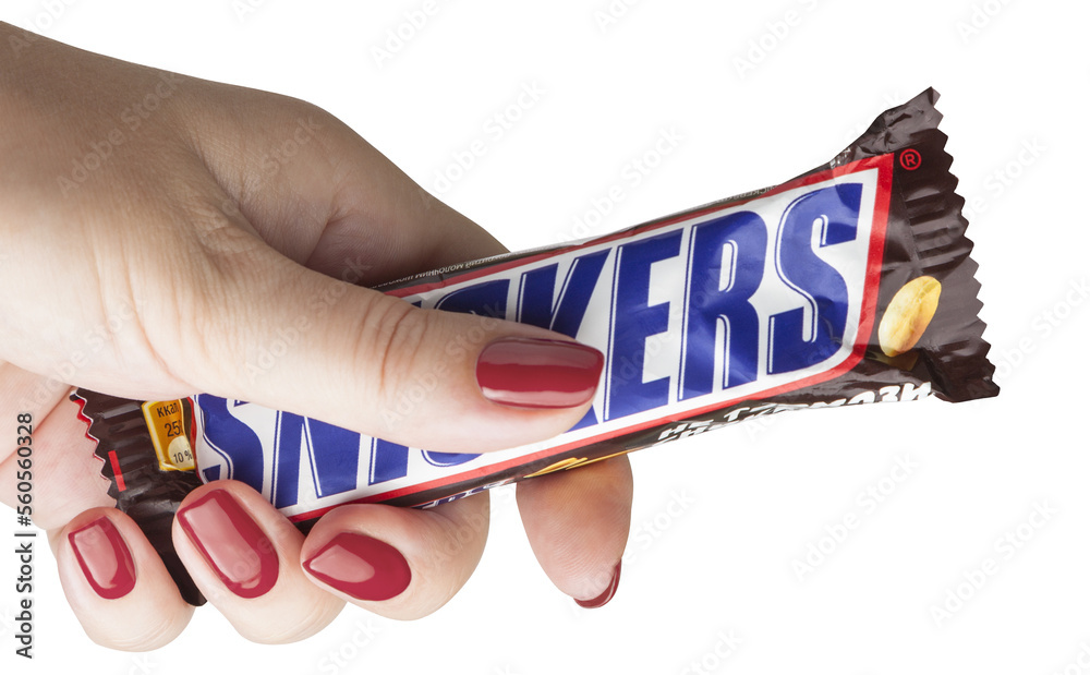 female hand holding a Snickers chocolate bar. Isolated on a transparent ...
