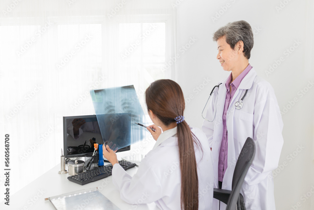 two Asian doctor looking patient film, they talk with treatment plan ...