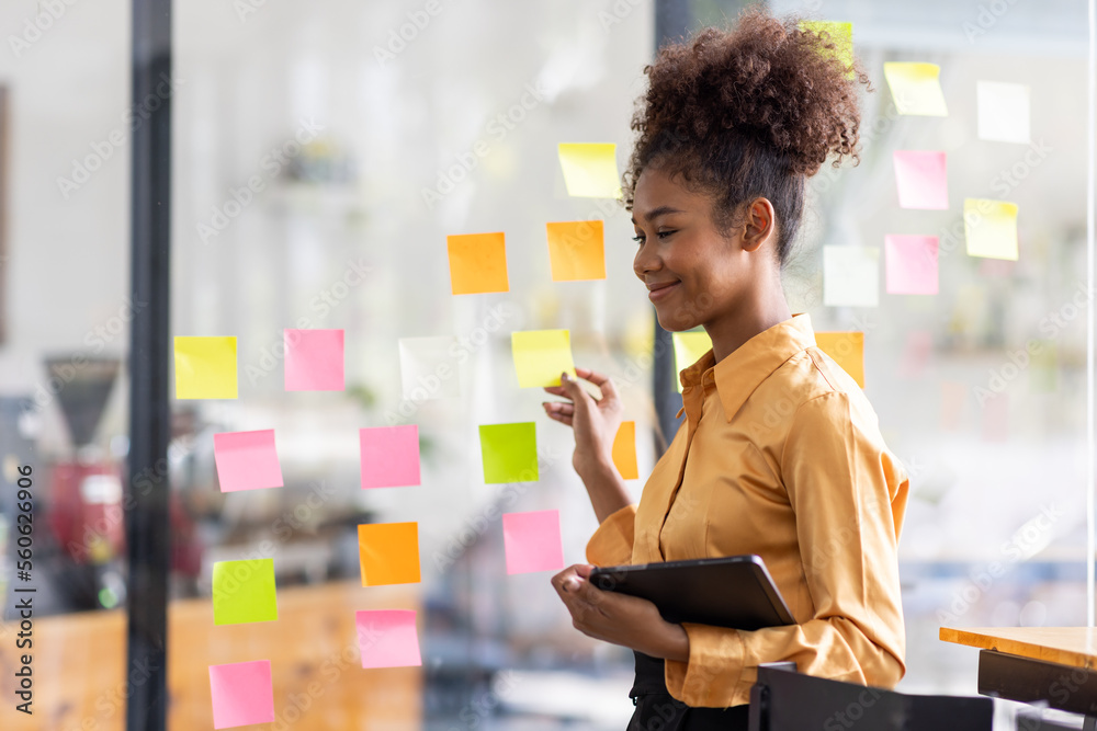 Foto de Young Serious african american Creative team use post it notes ...