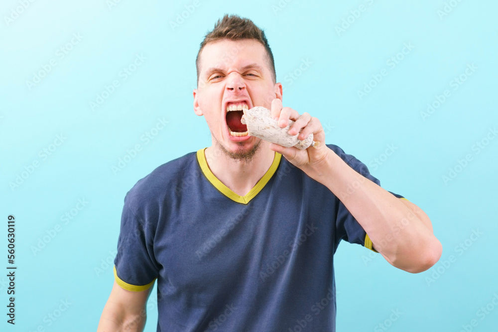 An angry an gungry man trying to eat white sausage on a blue background ...