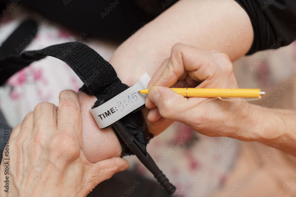 Writing a time on applied tourniquet - older women arm Stock Photo ...