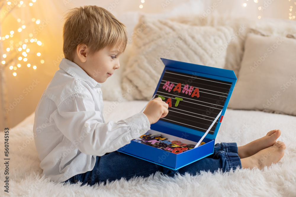 Cute little preschool child, playing with alphabet game, learning ...