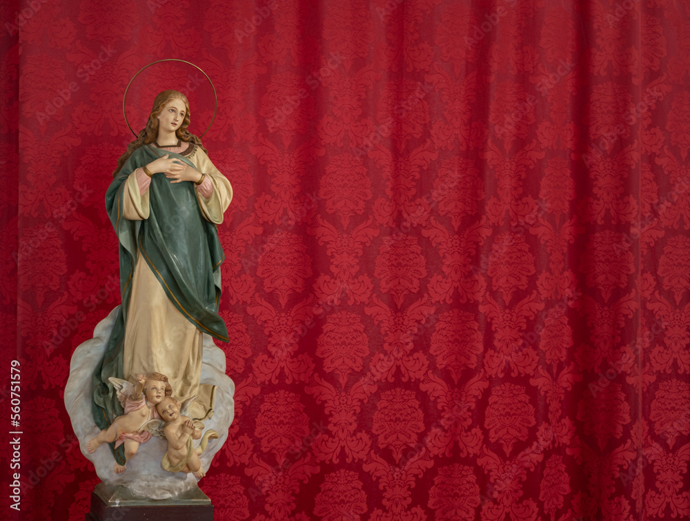 statue of the Virgin Mary on a red background. Catholic Church. Lord's ...