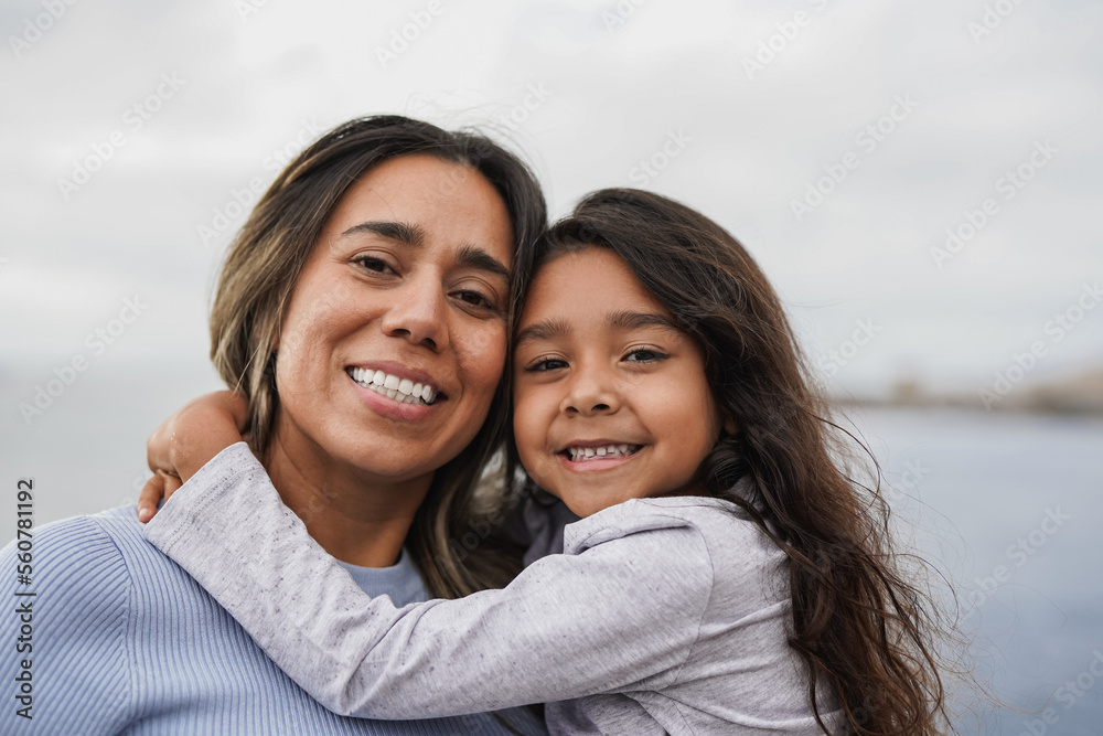 Cute latin girl hugging her mother outdoor - Mother and daughter love ...