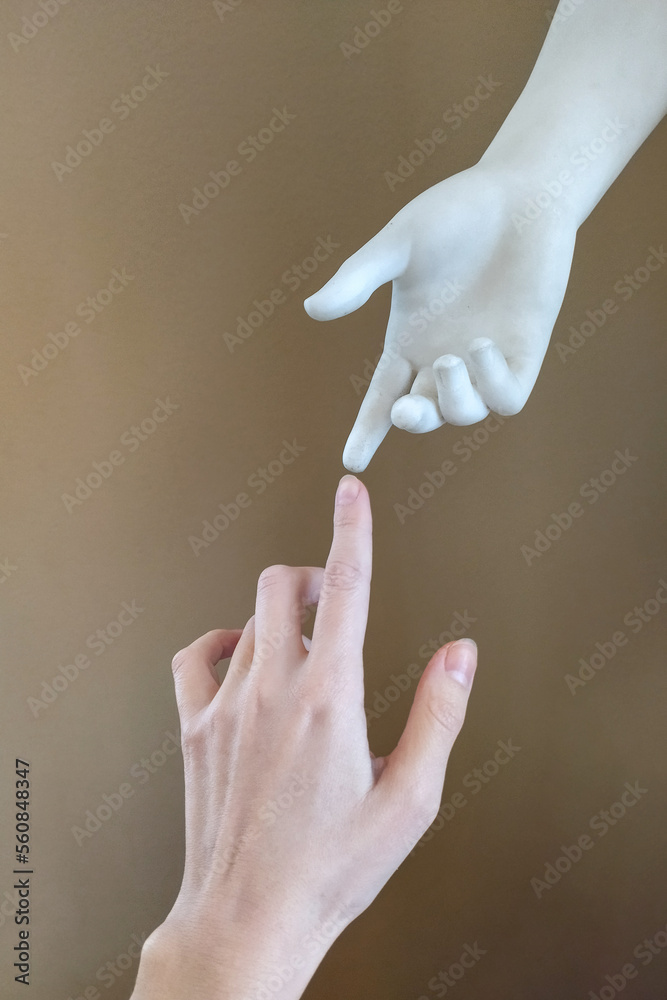 two hands, the hand of a statue and the hand of a man reaching for each ...