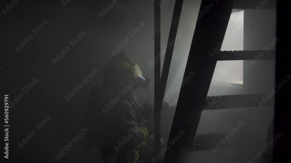 Dim, smoke filled room obscured scene. Firefighter appears crouched on ...