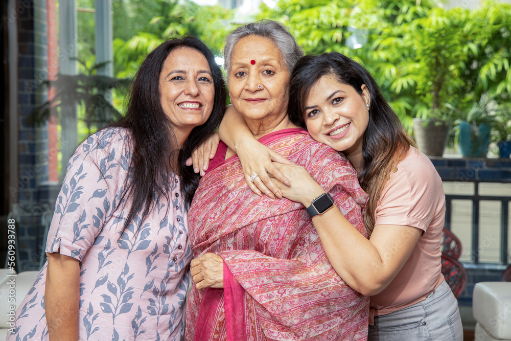 Two happy young indian daughters hug her mother at home, Love and ...
