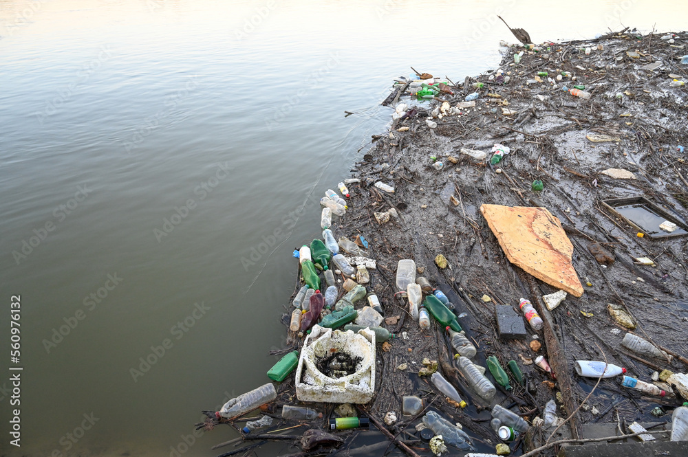 Water pollution. Garbage floating in contaminated river. Plastic bags ...