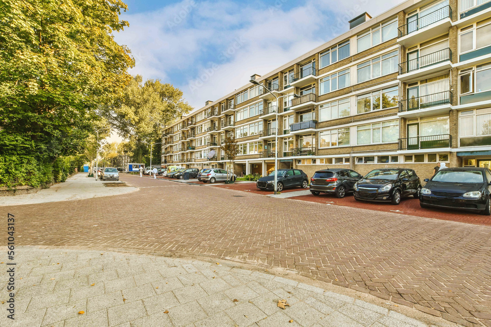 some cars parked on the side of a street in front of a multi - family ...