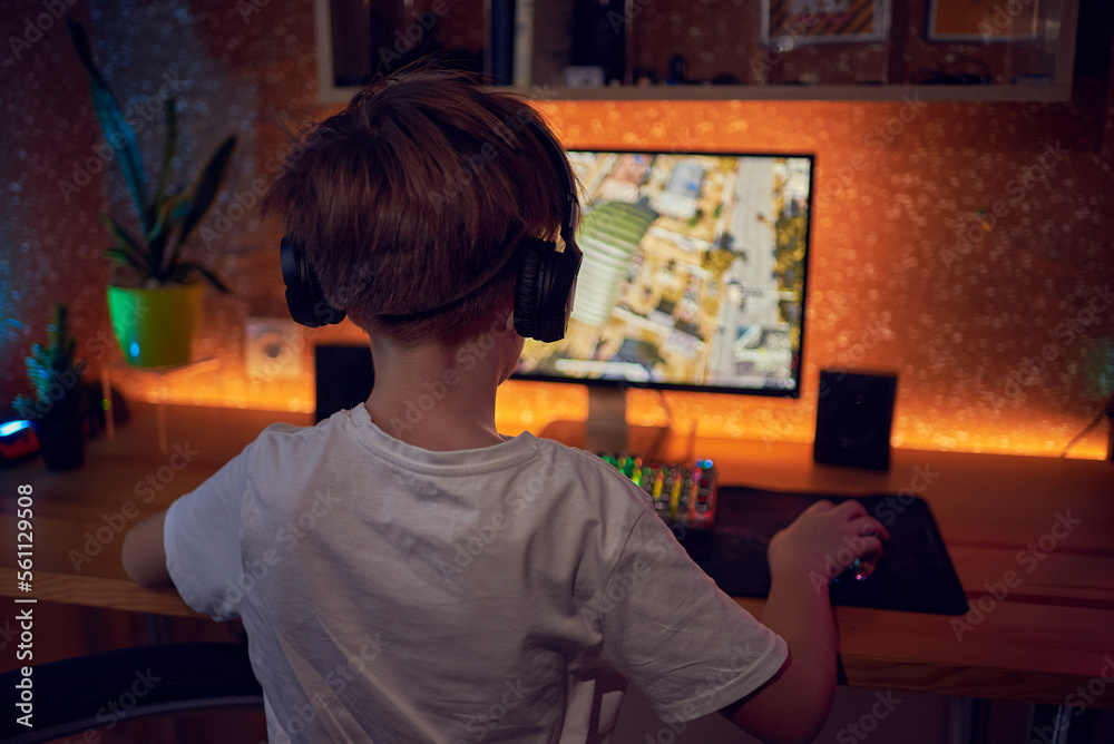 Hands of teenage gamer boy playing video games on computer in dark room ...