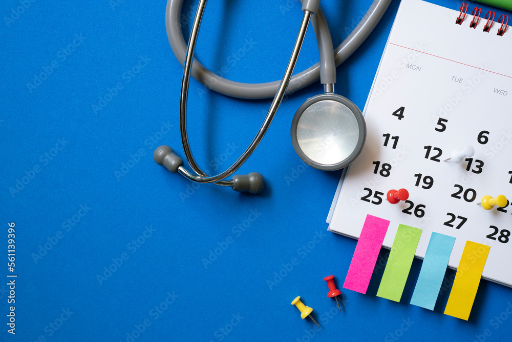 Top view of stethoscope and calendar on the blue background, schedule ...