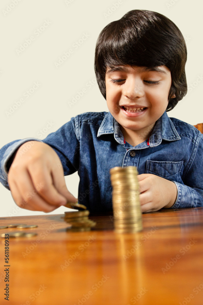 Little boy playing with coins making stacks and learning financial ...