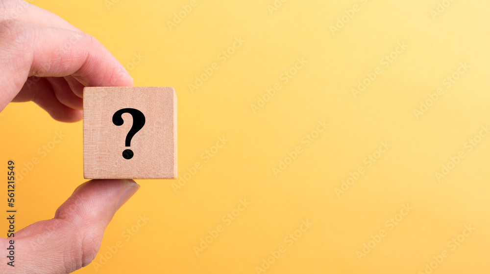 Hand holding question mark wooden block of business concept background ...