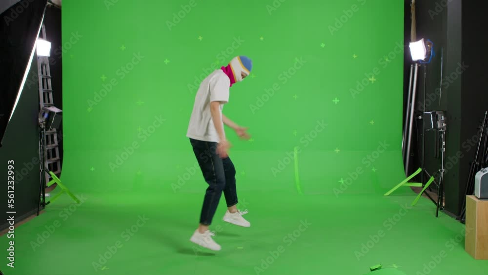Girl in white t-shirt, jeans and sneakers dancing on a Green Screen ...