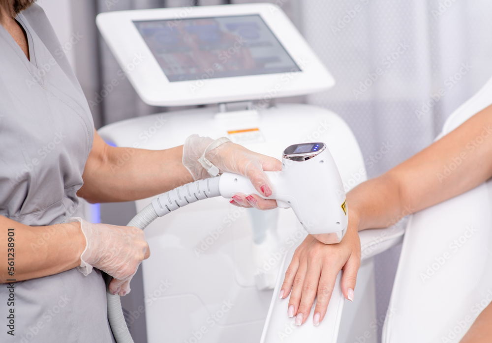 Professional beautician removes hair on beautiful female fingers using ...