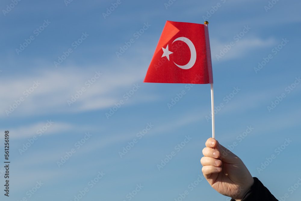 Turkish flag in hand flutters in the wind against the sky, independence ...