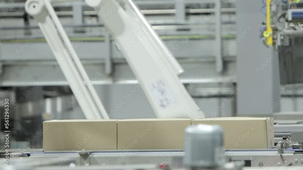 Automatic robot sorting carton boxes from a conveyor belt to a box in a ...