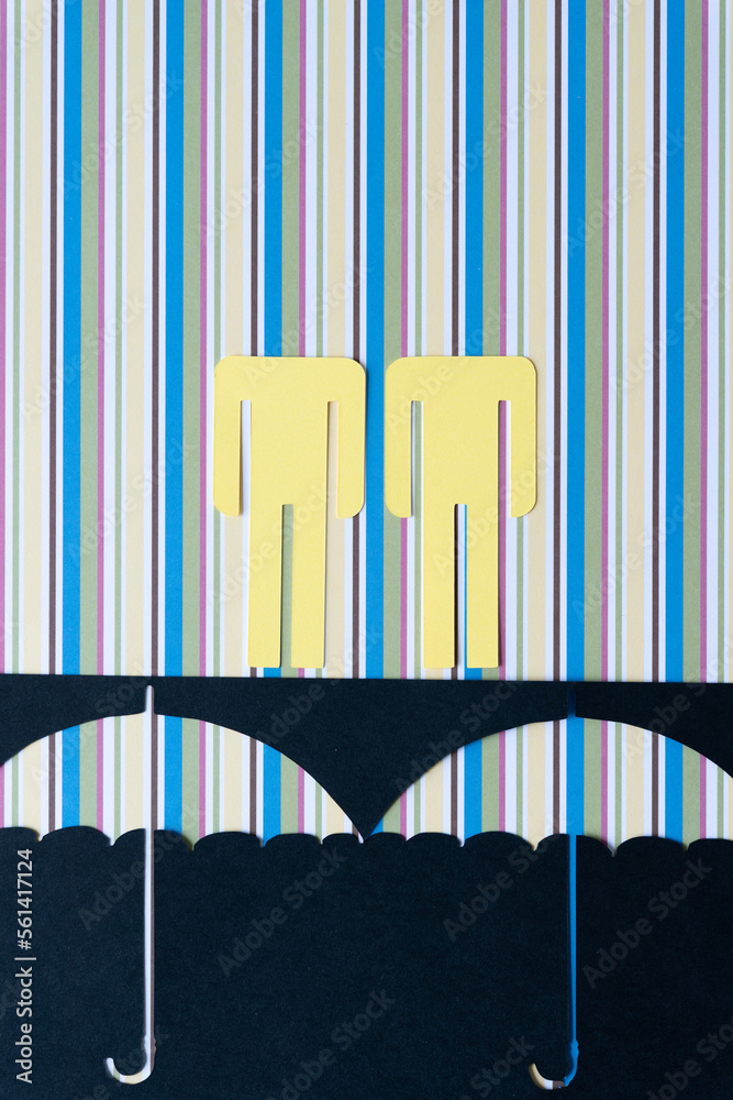 two yellow paper stick figures with invisible heads on stencil with ...