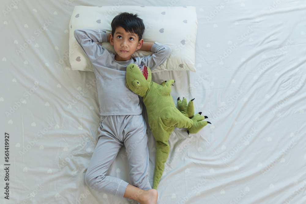 Top View of Asian boy smiling lying down on Bed in bedroom at home ...