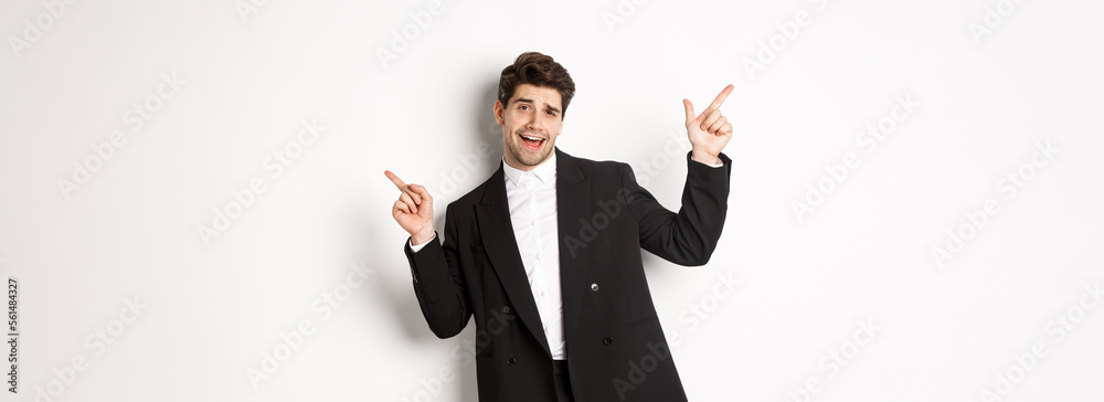 Handsome guy dancing and partying in black suit, pointing fingers ...