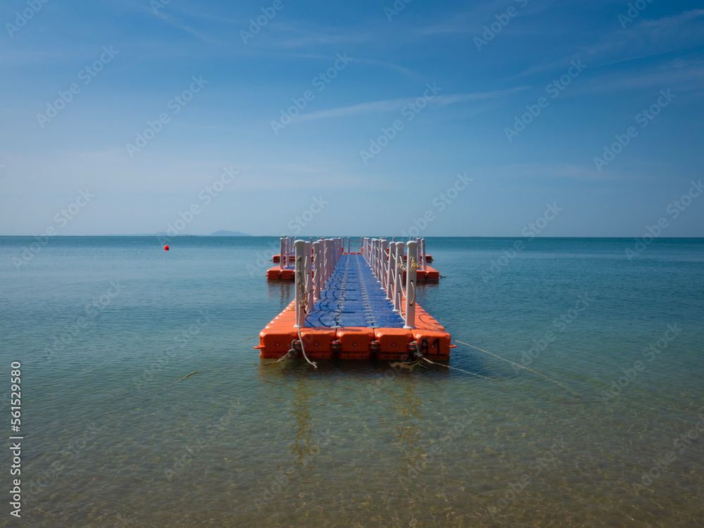 Orange and blue plastic floating pier with protection fence in the sea ...