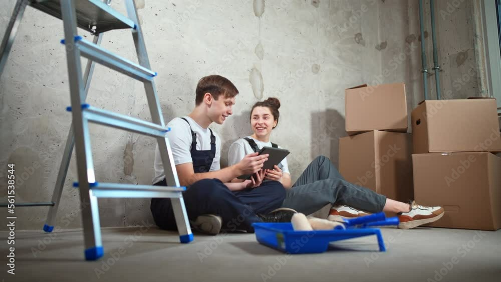 Guy and girl sitting on floor in apartment, laughing and talking ...