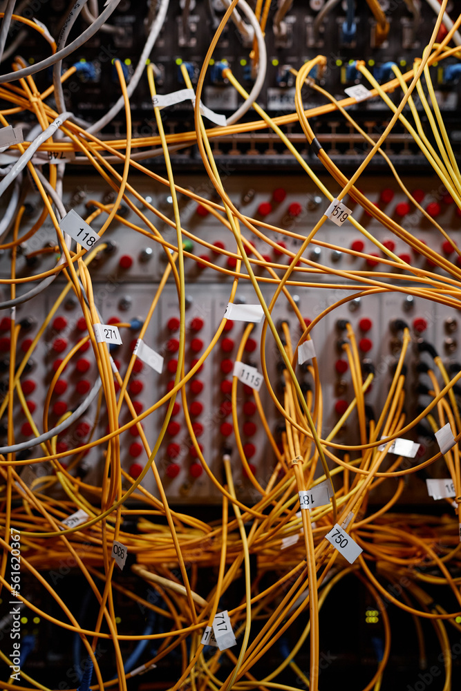 Vertical background image of server cabinet with yellow internet cables ...