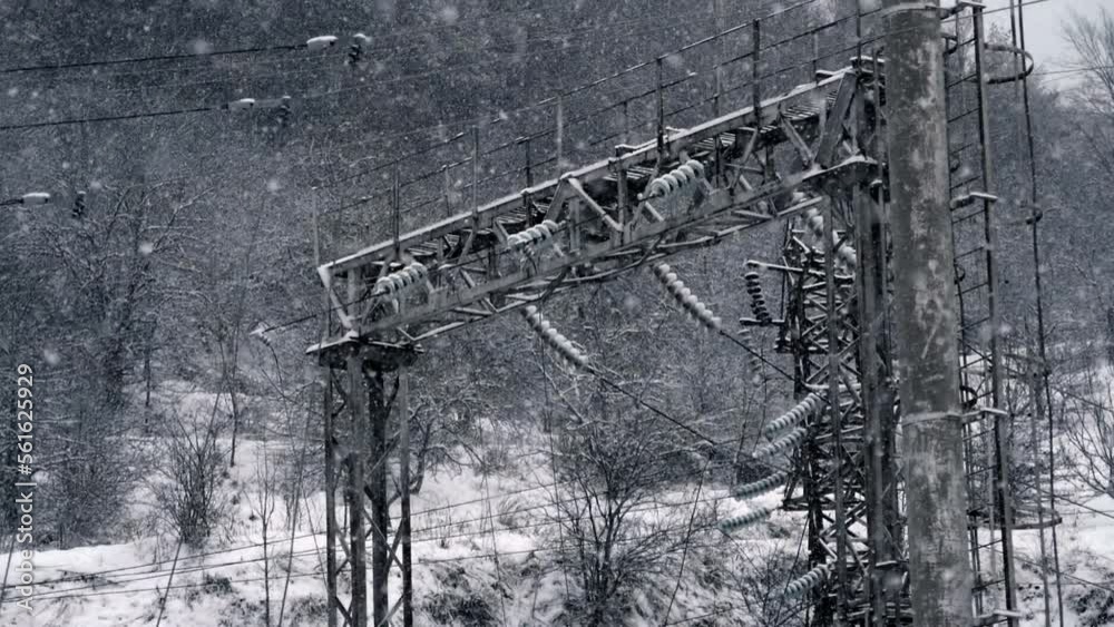 High-voltage wires with insulators on a metal poles near a transformer ...