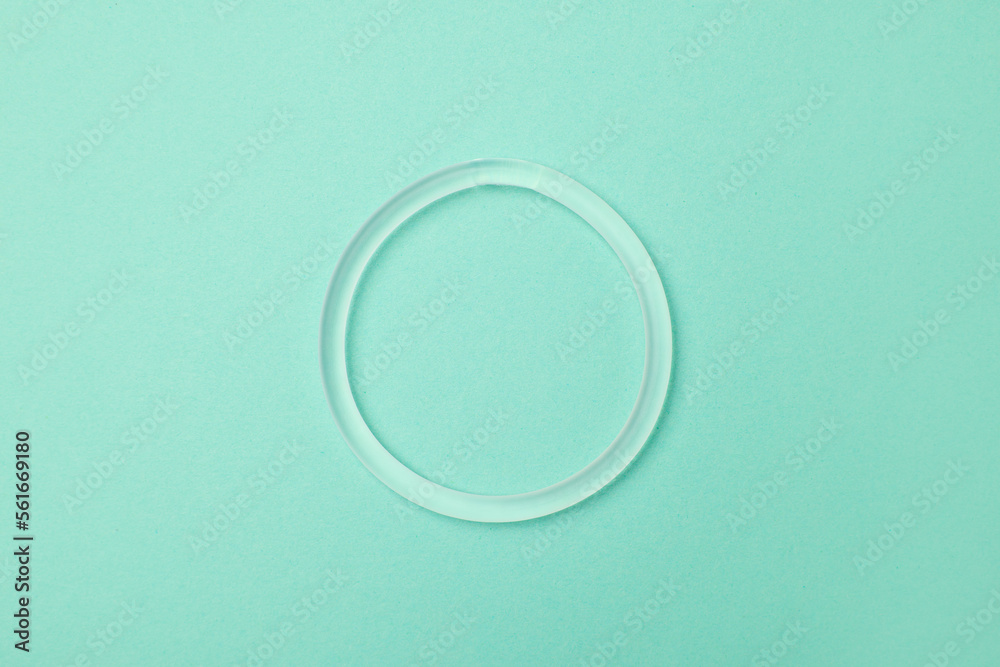 Diaphragm vaginal contraceptive ring on turquoise background, top view ...