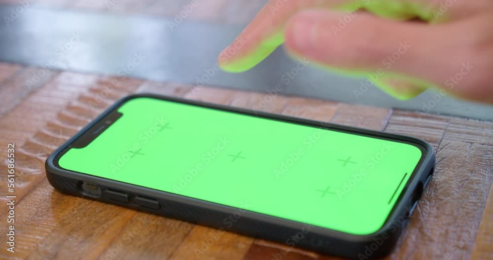 Iphone lying flat on a table, screen displayed in close-up, with green ...