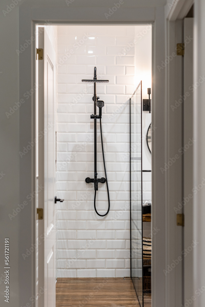Looking at shower area in bathroom through doorway in hallway. White ...