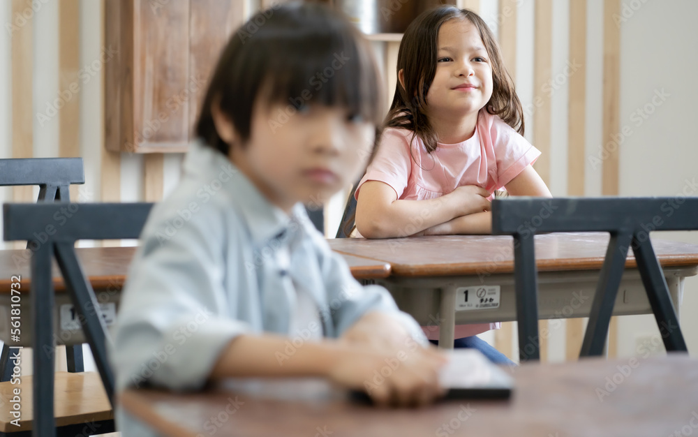 Girl child sitting at classroom desk studying lesson in elementary ...