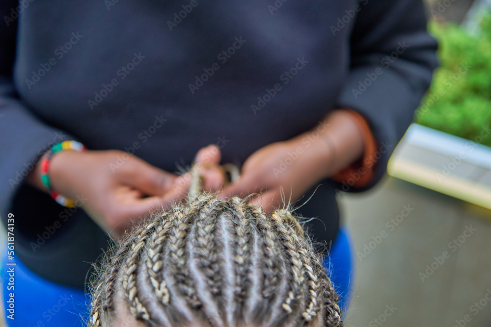 Close-up woman's head, process of weaving African hair by dark-skinned ...