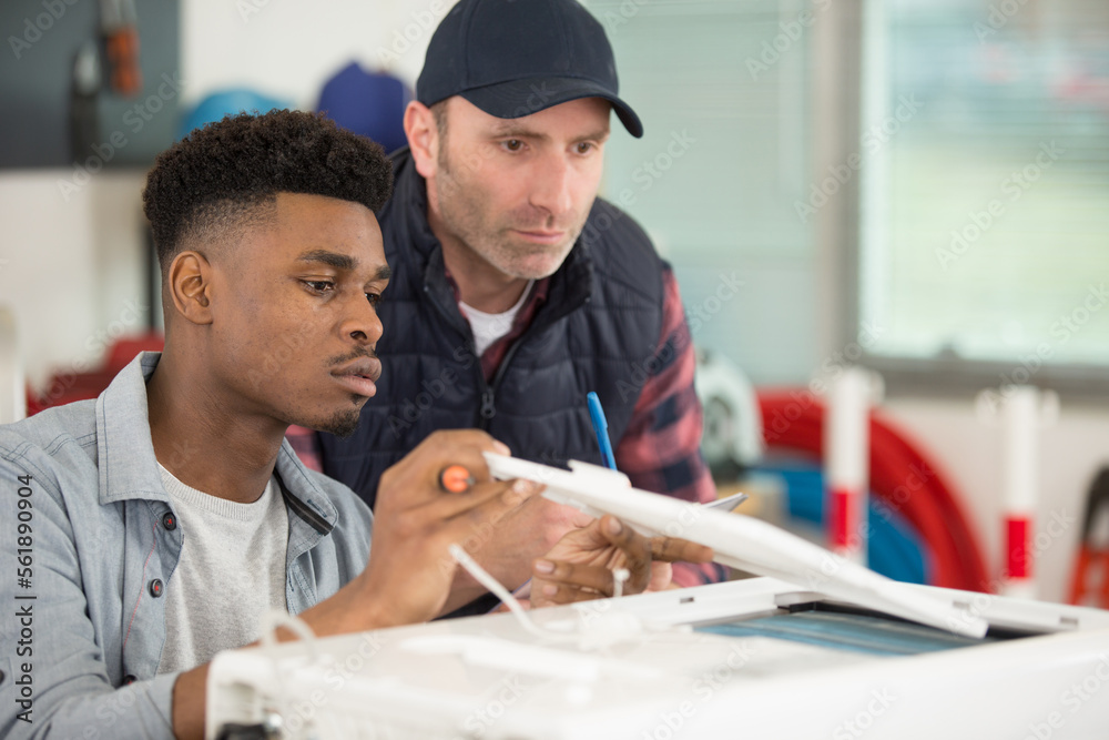 two workers working on the air conditioning unit Stock Photo | Adobe Stock
