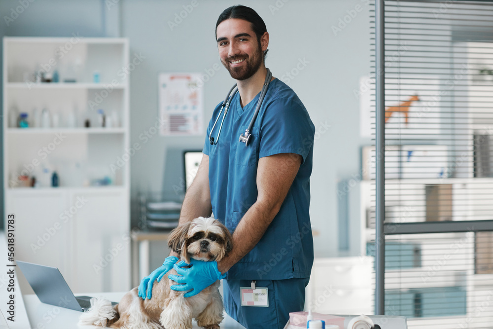 Young smiling veterinarian in blue uniform standing by workplace Stock ...
