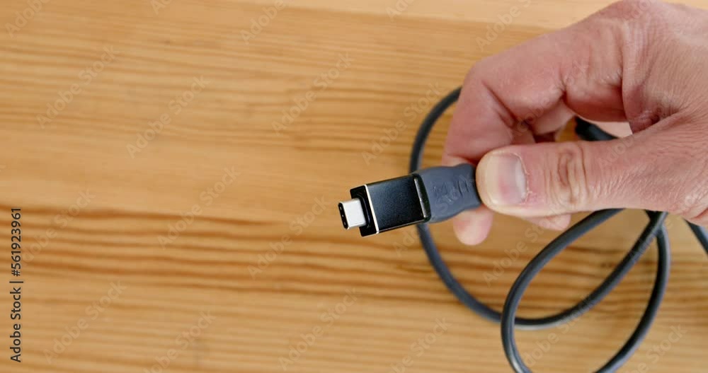 Close-up, using adapters to connect a cable to a digital device ...