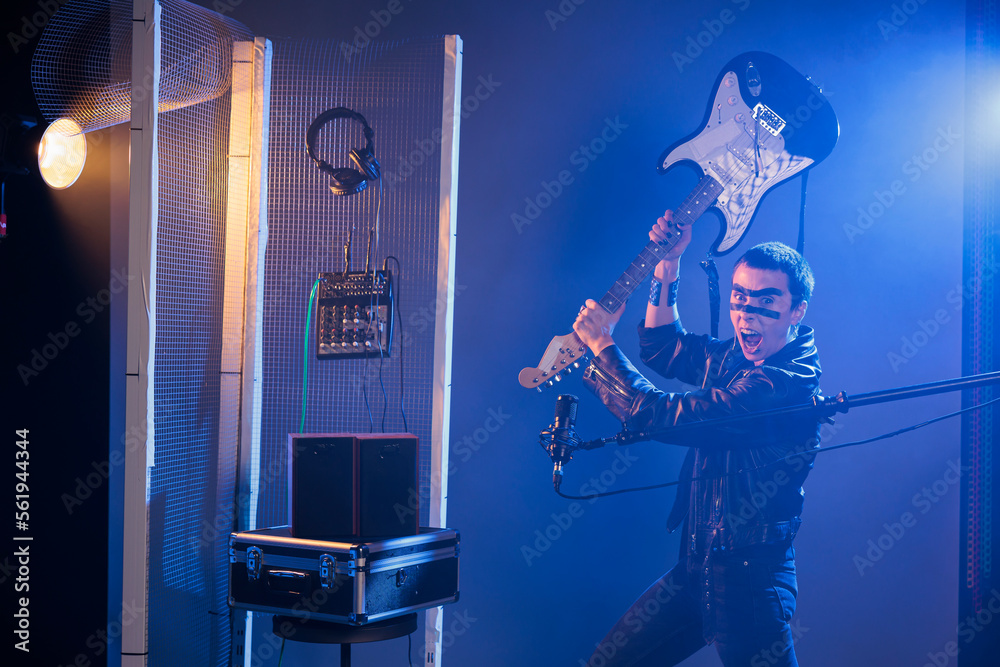 Ecstatic artist holding bass guitar to smash and act crazy, performing ...